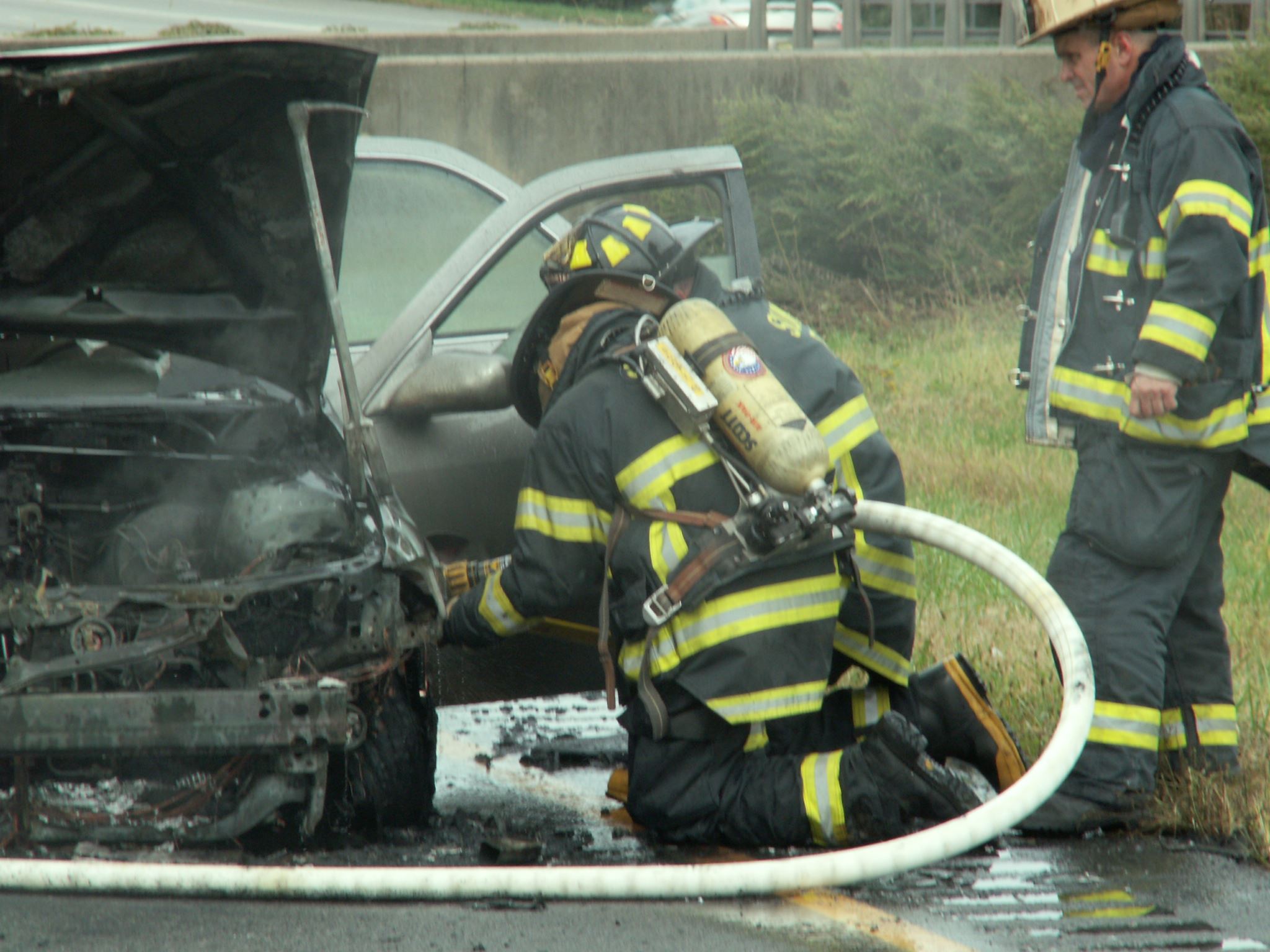 Photo Gallery • Firefighter kneeling next to car